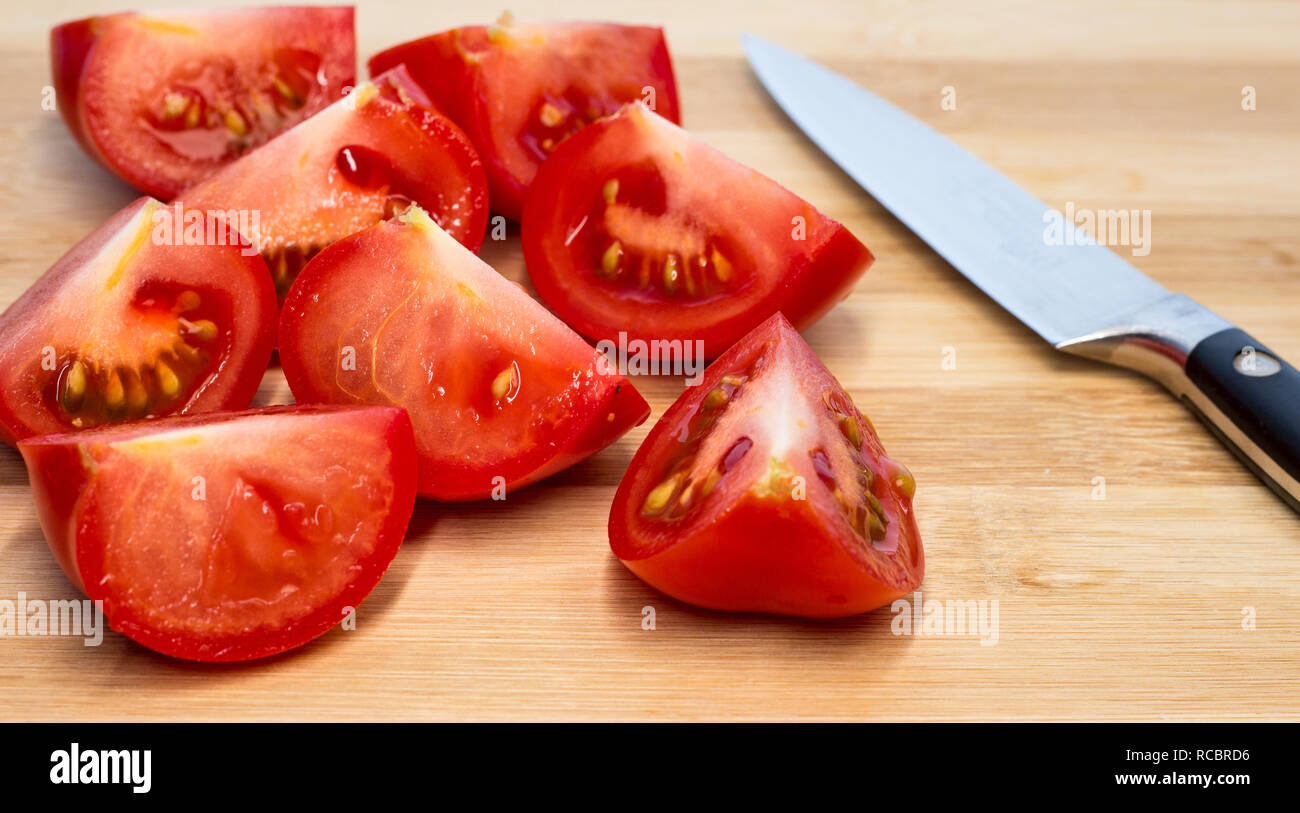 Cut red tomatoes and small knife Stock Photo - Alamy