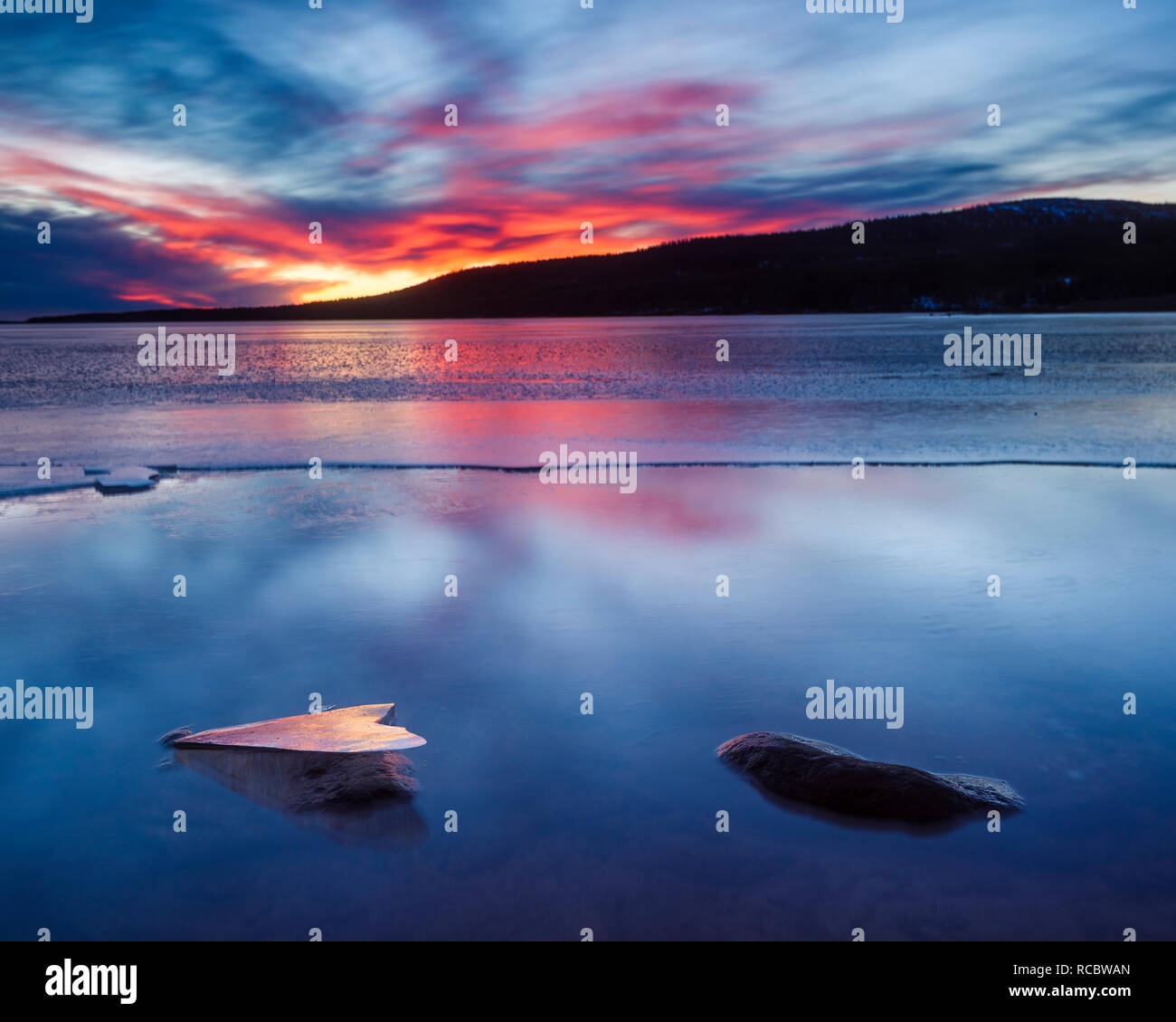 Ice on beach at sunset Stock Photo - Alamy