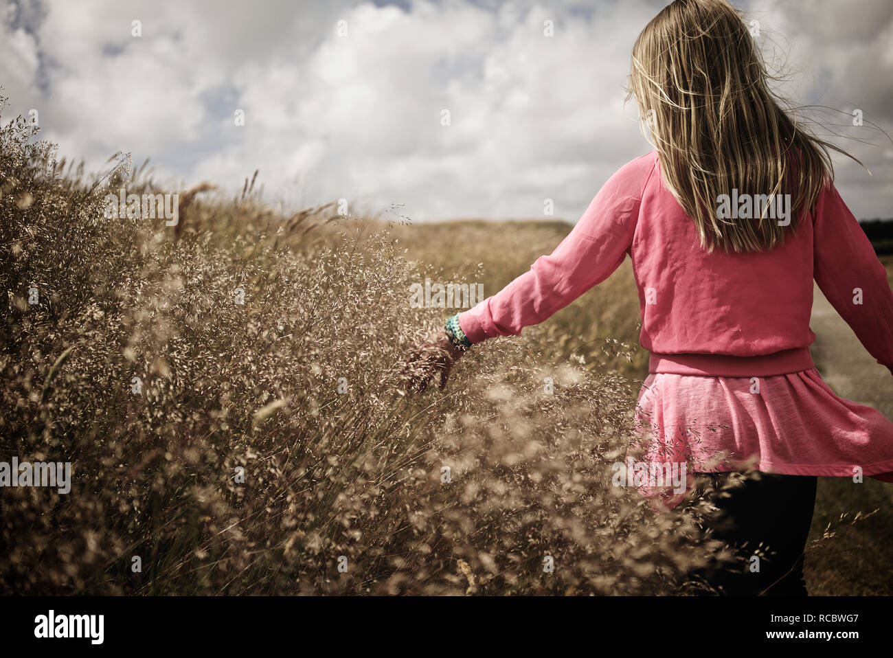 Girl walking on meadow Stock Photo - Alamy