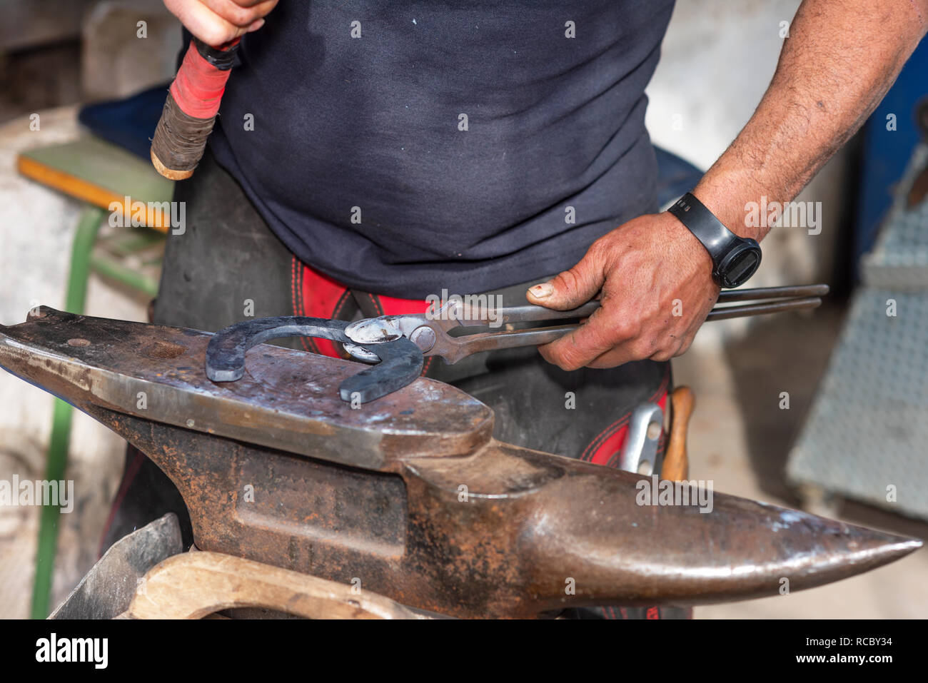 Blacksmith working on the anvil, making a horseshoe Stock Photo - Alamy