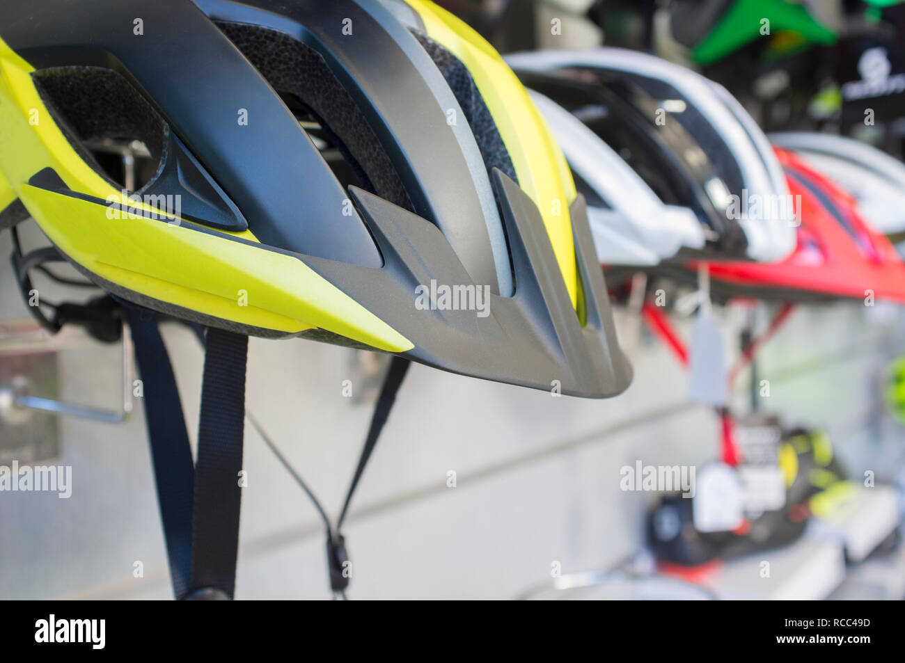 New bike helmets displayed on shop. Painted with reflecting color ...