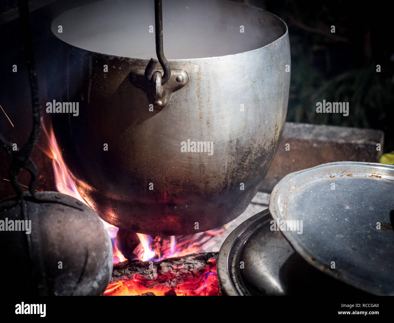 Old pot hanging from the fireplace above the wood fire Stock Photo - Alamy