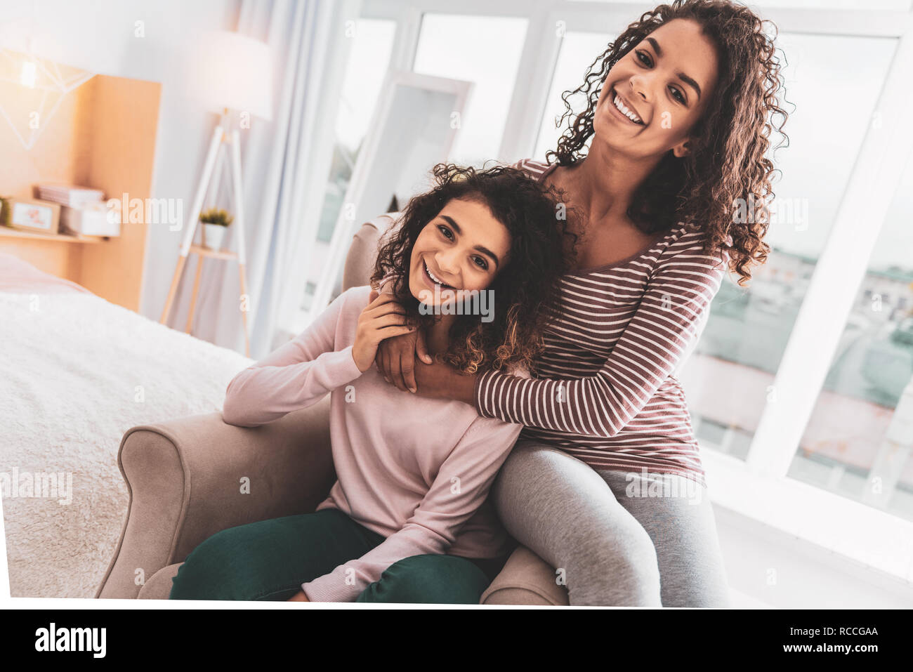 Smiling curly girl hugging her best friend Stock Photo - Alamy Smiling curly girl hugging her best friend Stock Photo - Alamy