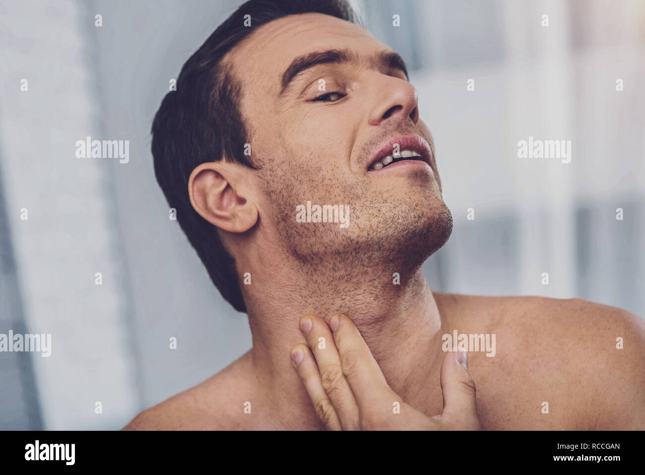 Positive handsome man applying a lotion Stock Photo - Alamy