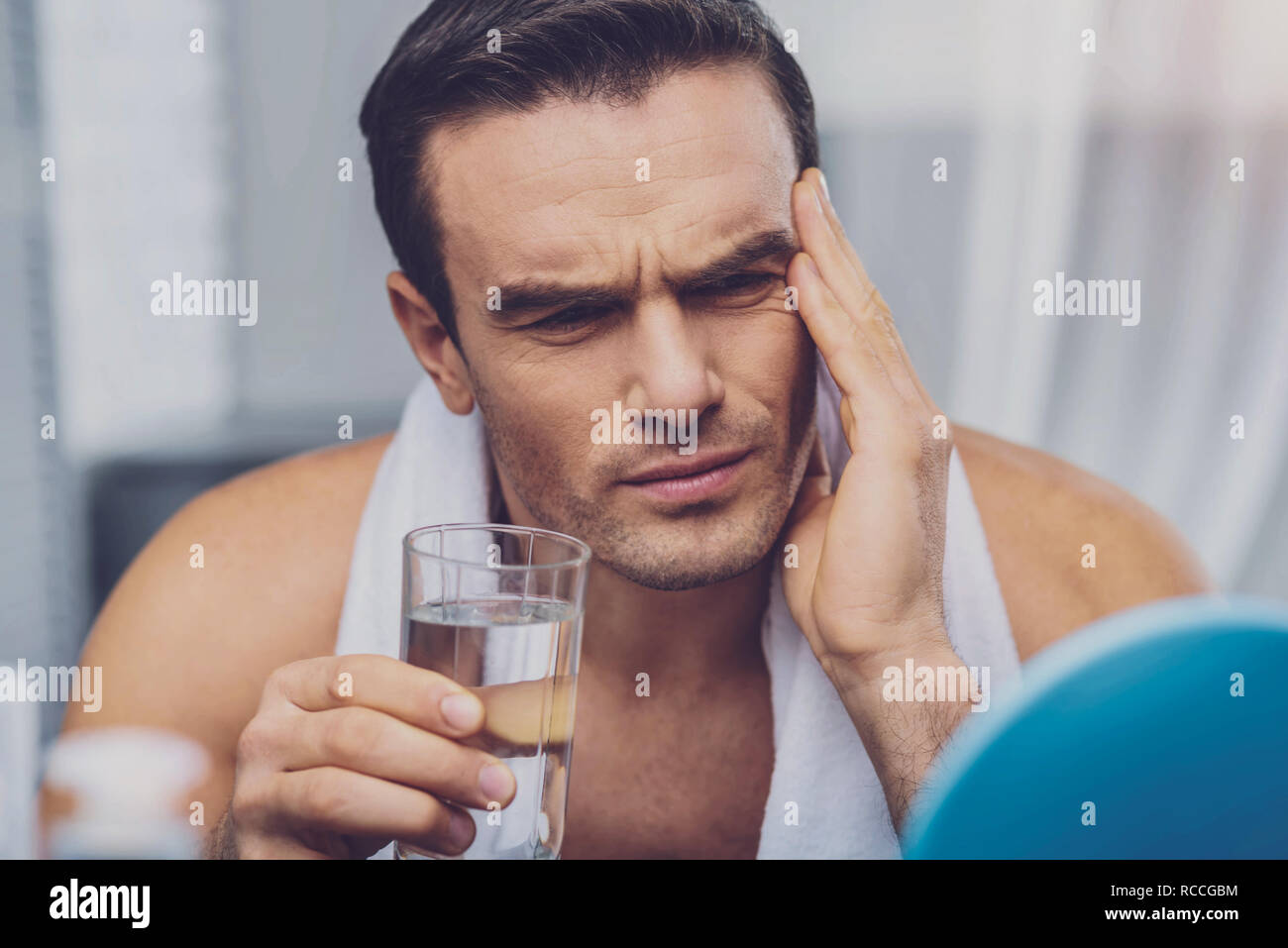 Sad young man having hangover Stock Photo - Alamy