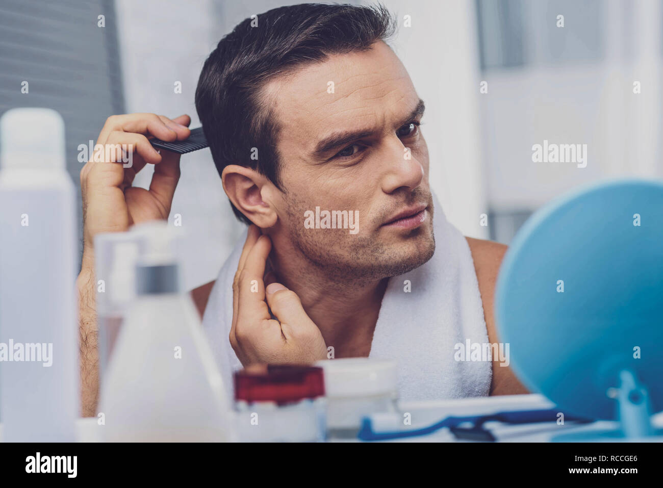 Nice handsome man combing his hair Stock Photo - Alamy