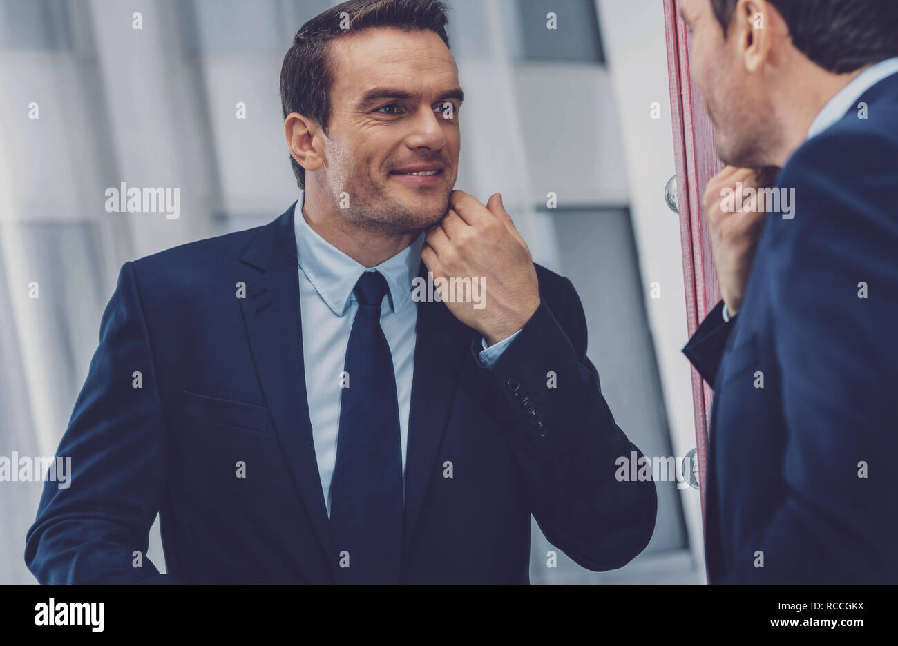Cheerful handsome man looking into the mirror Stock Photo - Alamy