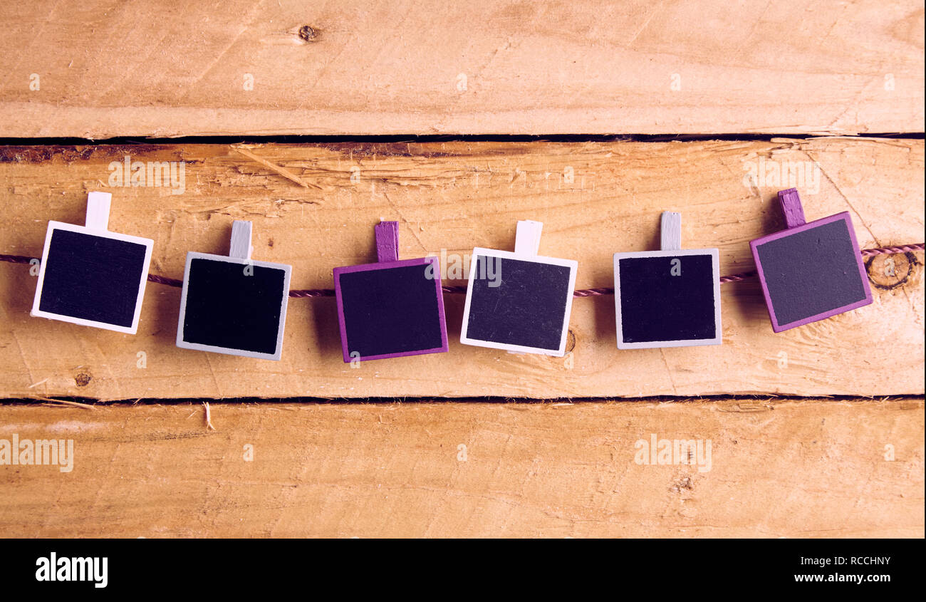 Row of blank instant photo frames hanging from pegs on a string ...