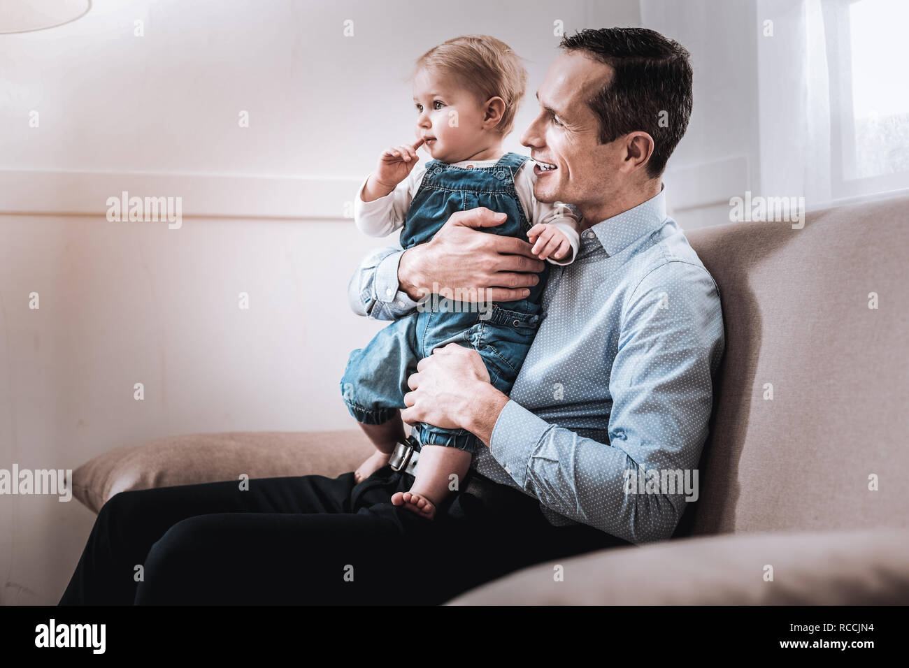 Positive delighted man holding his son Stock Photo - Alamy Positive delighted man holding his son Stock Photo - Alamy