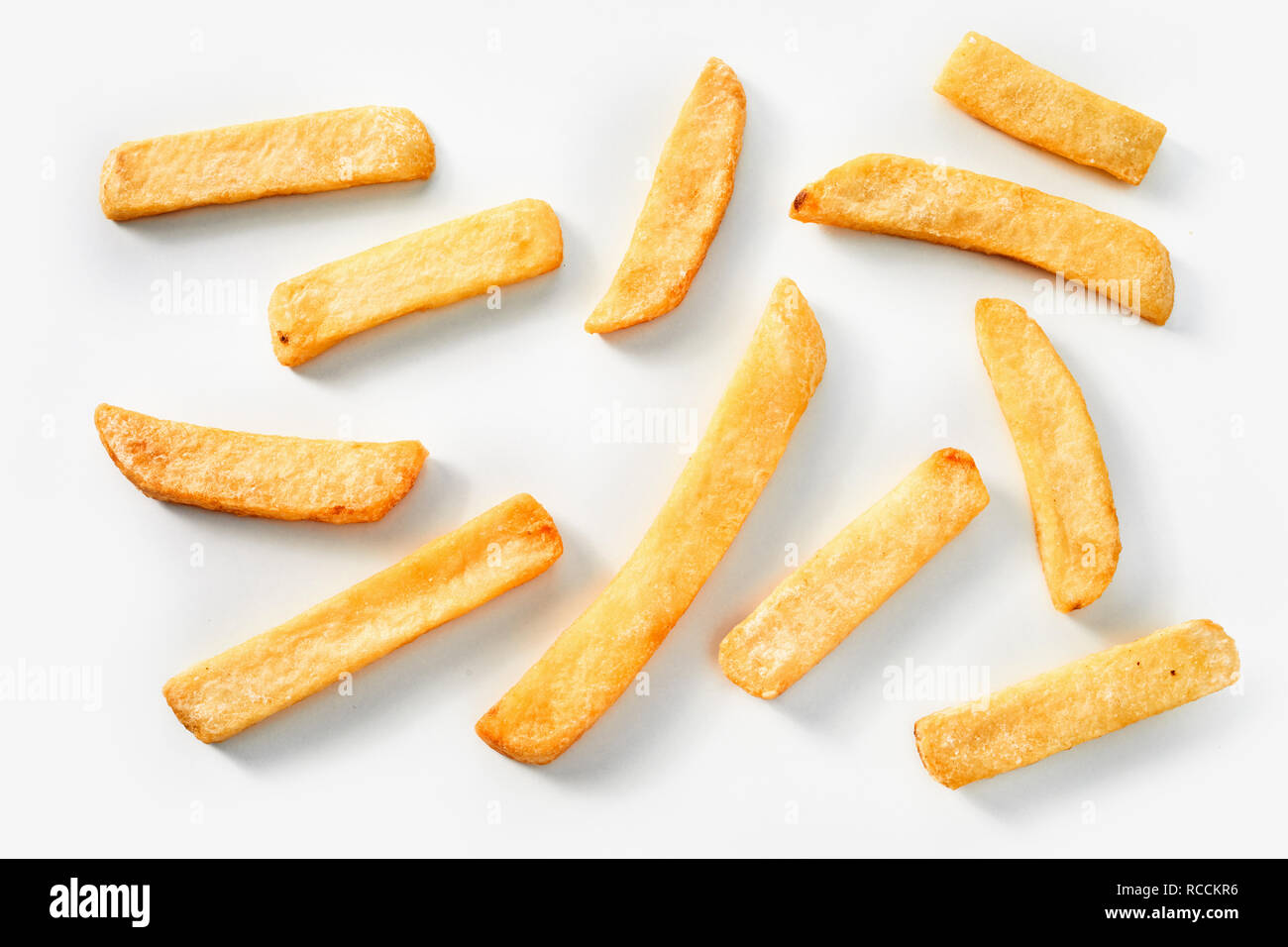 Homemade deep fried French fries on a white background in a random ...
