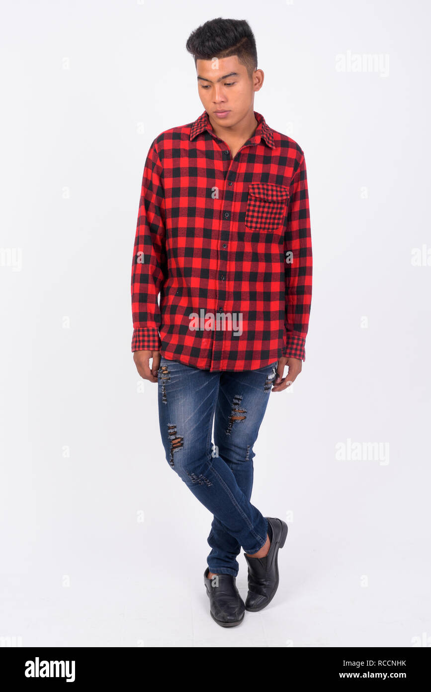 Full body shot of young Asian hipster man looking down against white ...