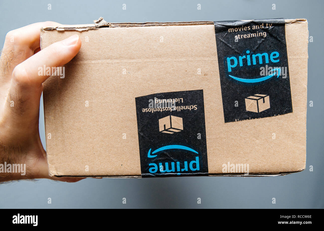 PARIS, FRANCE - JAN 6, 2018: Hand holding cardboard box with Amazon ...