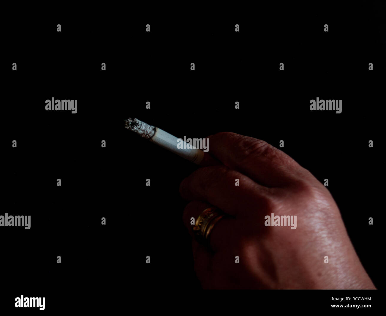 The hand of a woman smoking a cigarette Stock Photo - Alamy