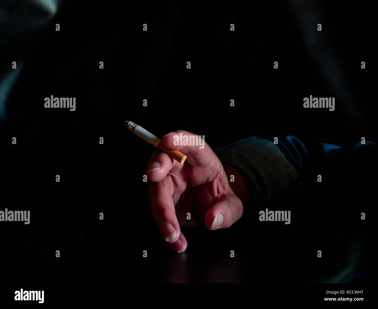 The hand of a woman smoking a cigarette Stock Photo - Alamy