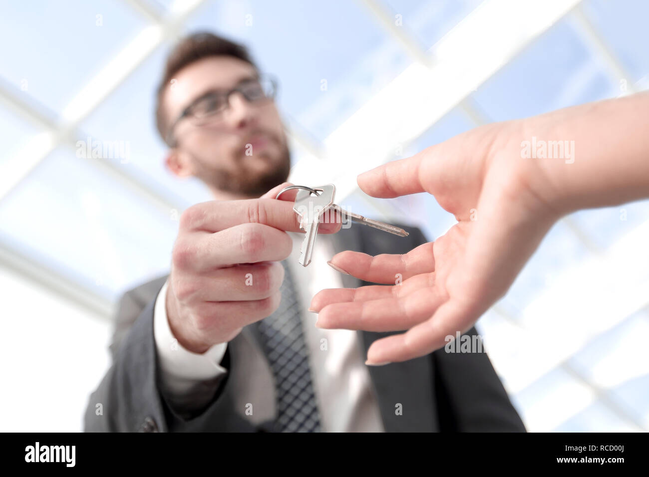 Cropped image of estate agent giving house keys to man in office Stock ...