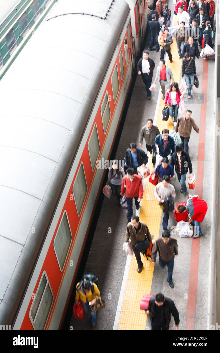 Aerial view of crowd of people disembarking and walking along train ...