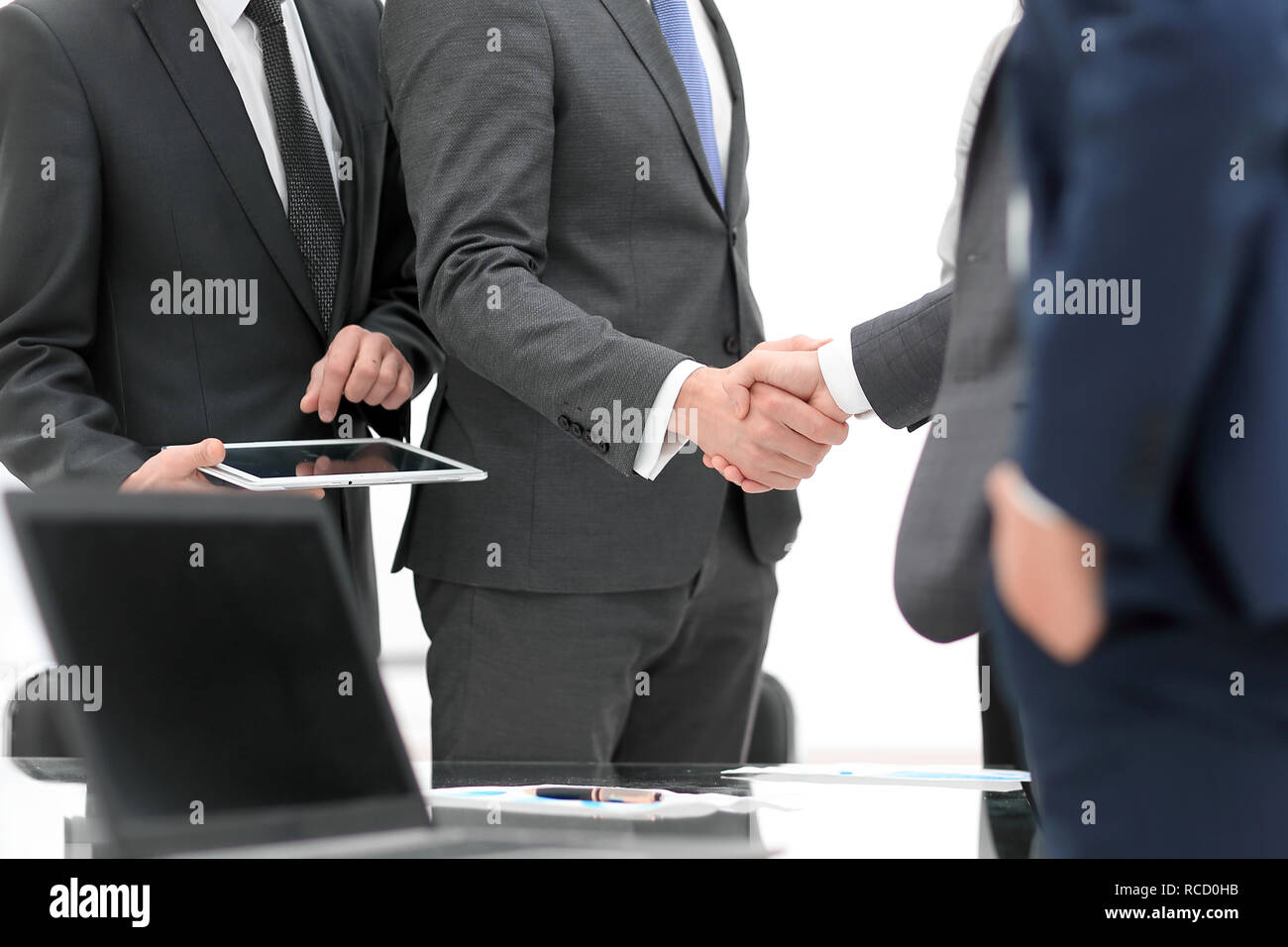 Business partners handshaking with their colleagues Stock Photo - Alamy