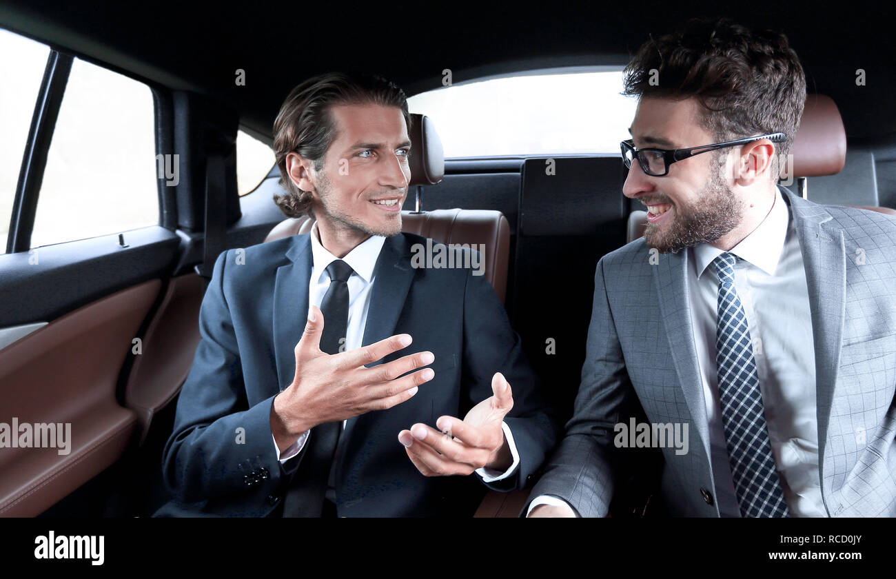 two businessman talking while sitting in the car Stock Photo - Alamy