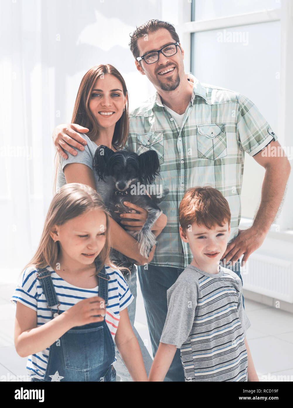 happy family on the background of a bright living room Stock Photo - Alamy