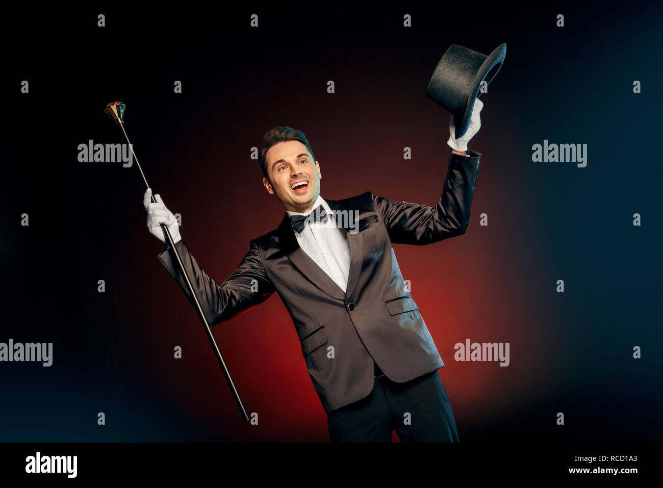 Professional showman wearing suit standing isolated on black and red ...