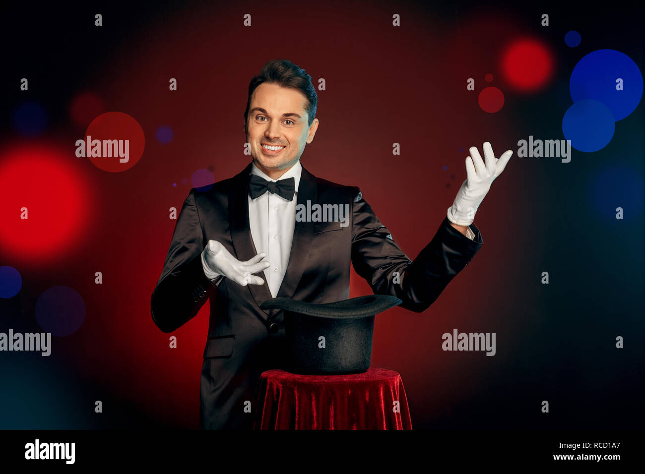 Professional magician wearing suit and gloves standing isolated on ...