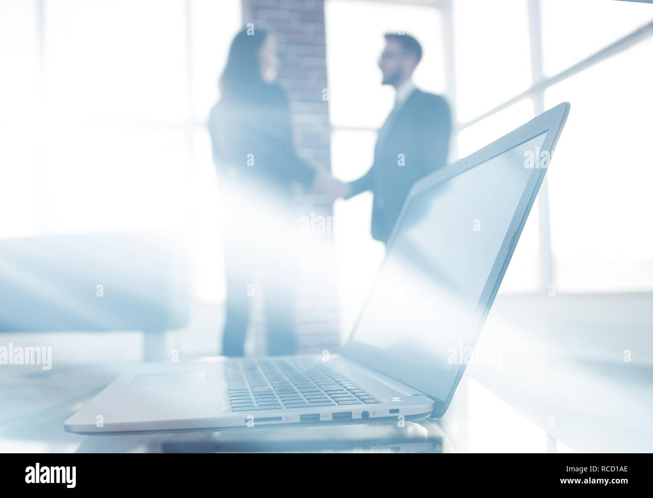 laptop on the desk, background handshake Stock Photo - Alamy