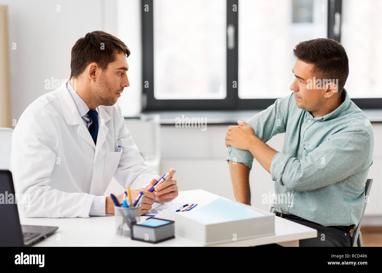 patient showing sore arm to doctor at hospital Stock Photo - Alamy