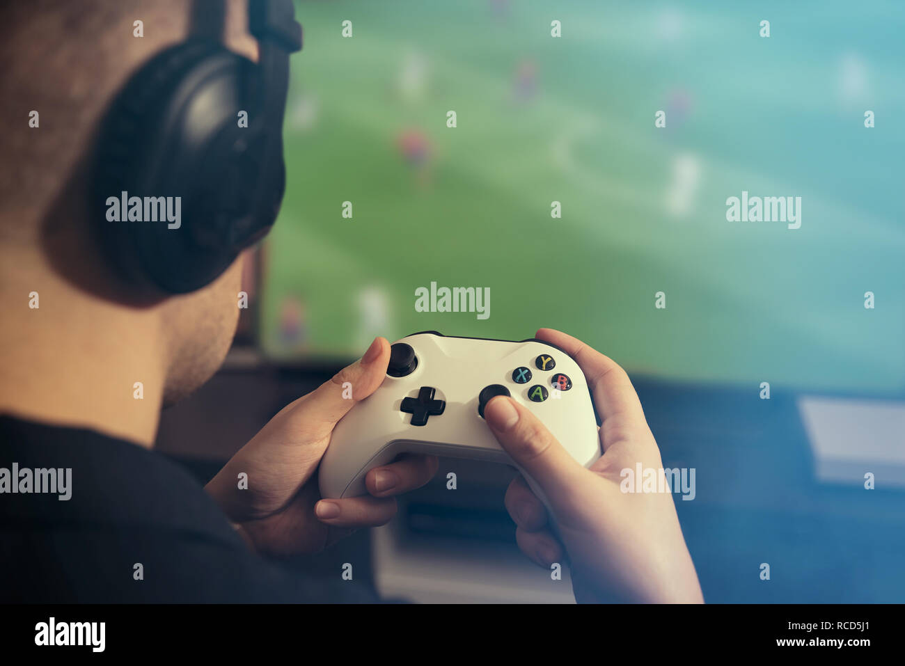 Man is playing on the console. Man holding gamepad and playing soccer ...