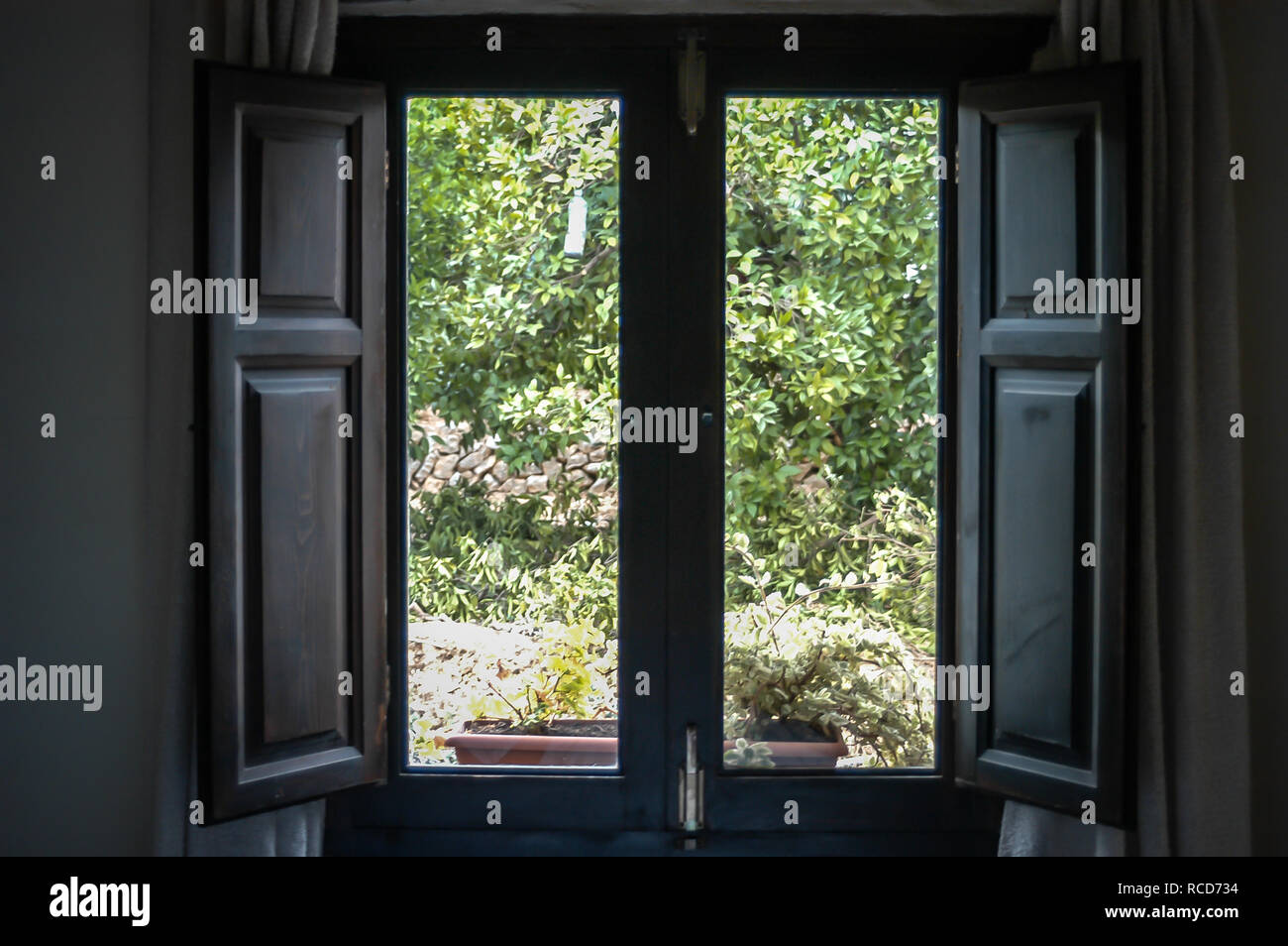 Looking out to the garden through a window with internal open wooden ...