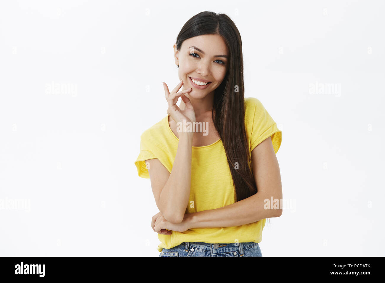 Charming young and friendly dark-haired female in trendy yellow t-shirt ...