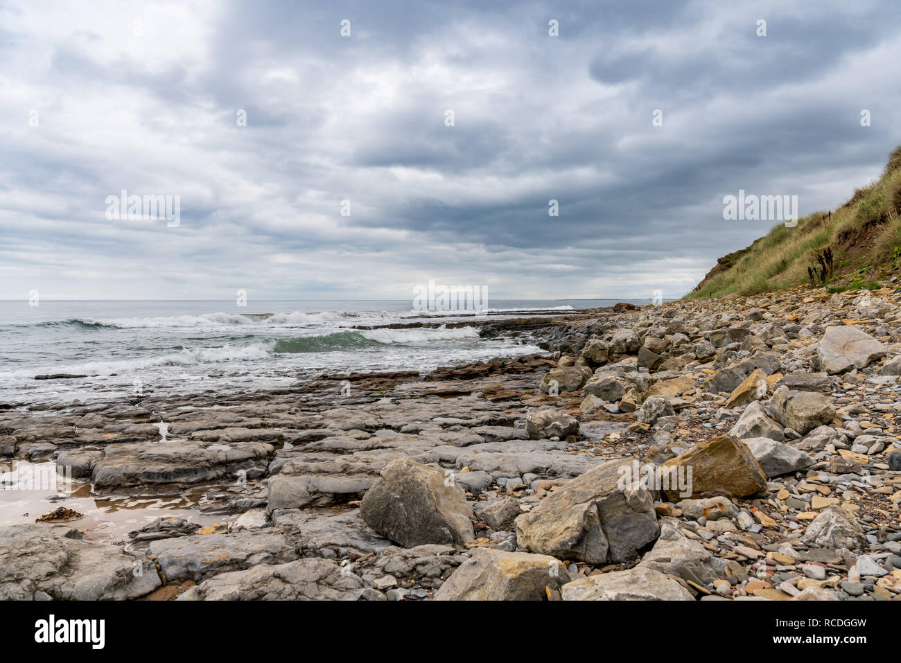 Dark clouds and large stones, seen at Cocklawburn Beach near Berwick ...