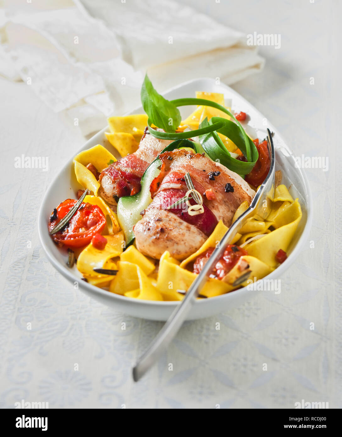 Tender pork fillet wrapped in ham served on ribbon pasta with roasted ...