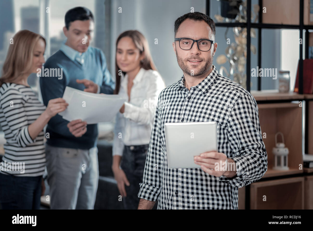 Alert man standing with his tablet Stock Photo - Alamy