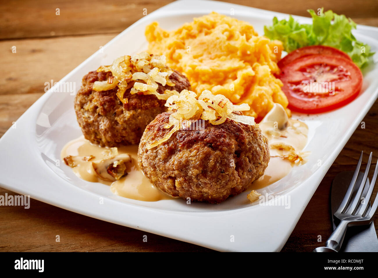 Spicy savory German frikadellen or meatballs topped with fried onions ...