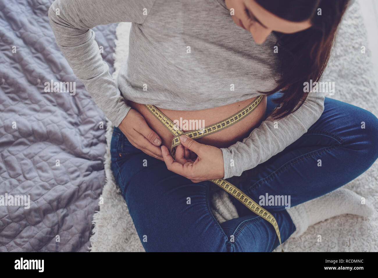 Top view of a young pregnant woman measuring abdomen Stock Photo - Alamy