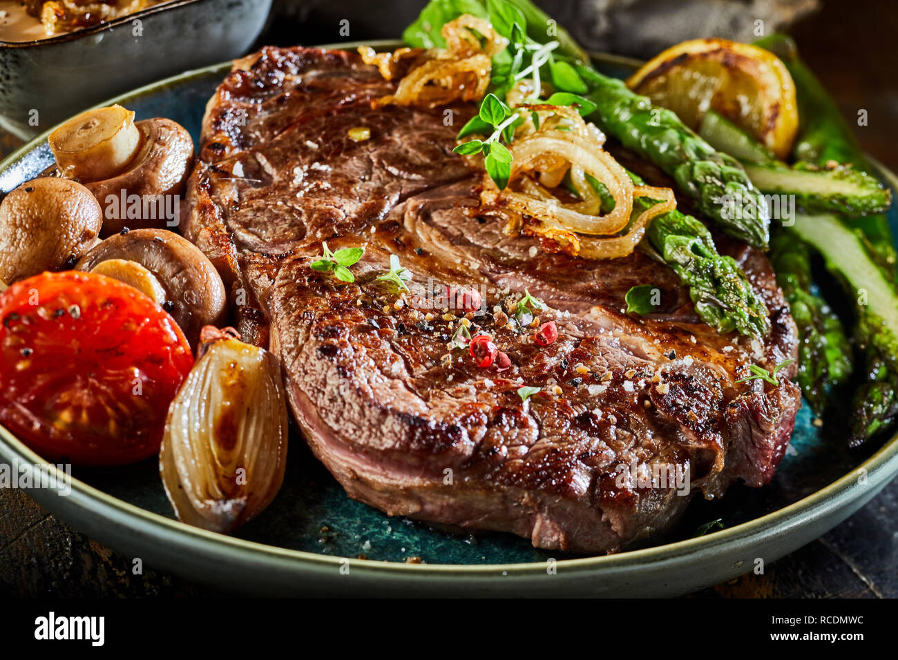 Meat stake served with roasted asparagus, mushrooms and vegetables ...