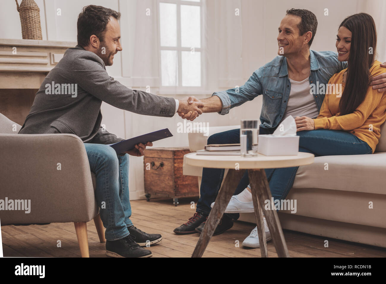 Skillful family expert shaking hand of his client Stock Photo - Alamy