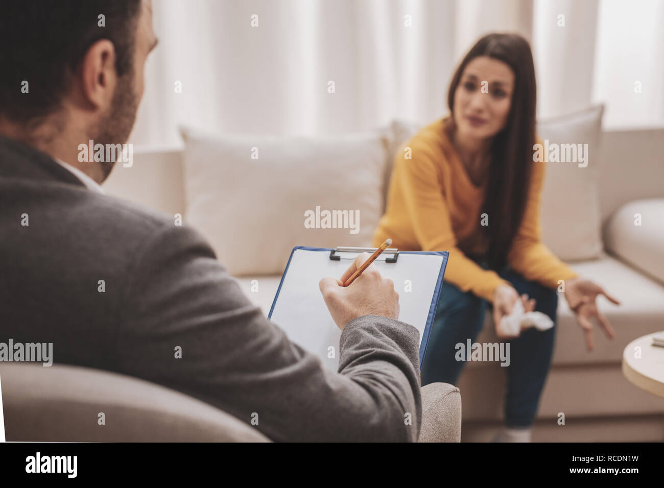 Attentive psychologist holding pencil in his hands Stock Photo - Alamy