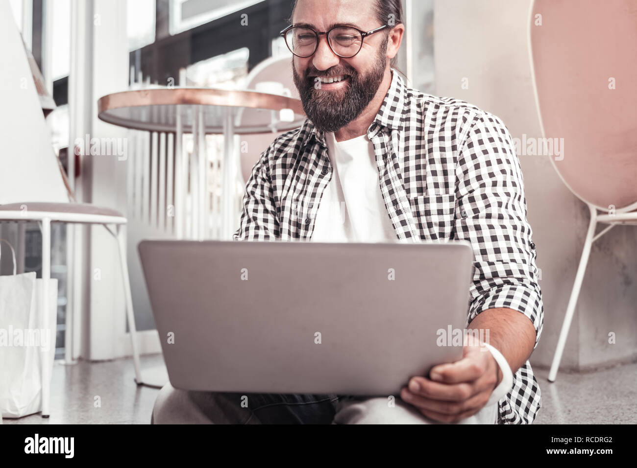 Smiling man holding the notebook while working Stock Photo - Alamy