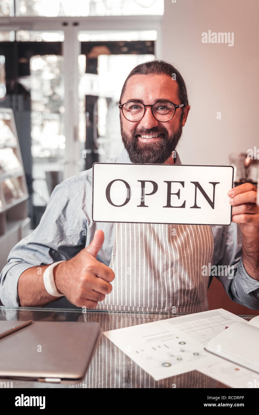 Happy shop owner holding the open sign Stock Photo - Alamy