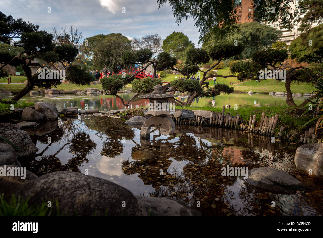Coins in a small japanese pond with reflections Stock Photo - Alamy