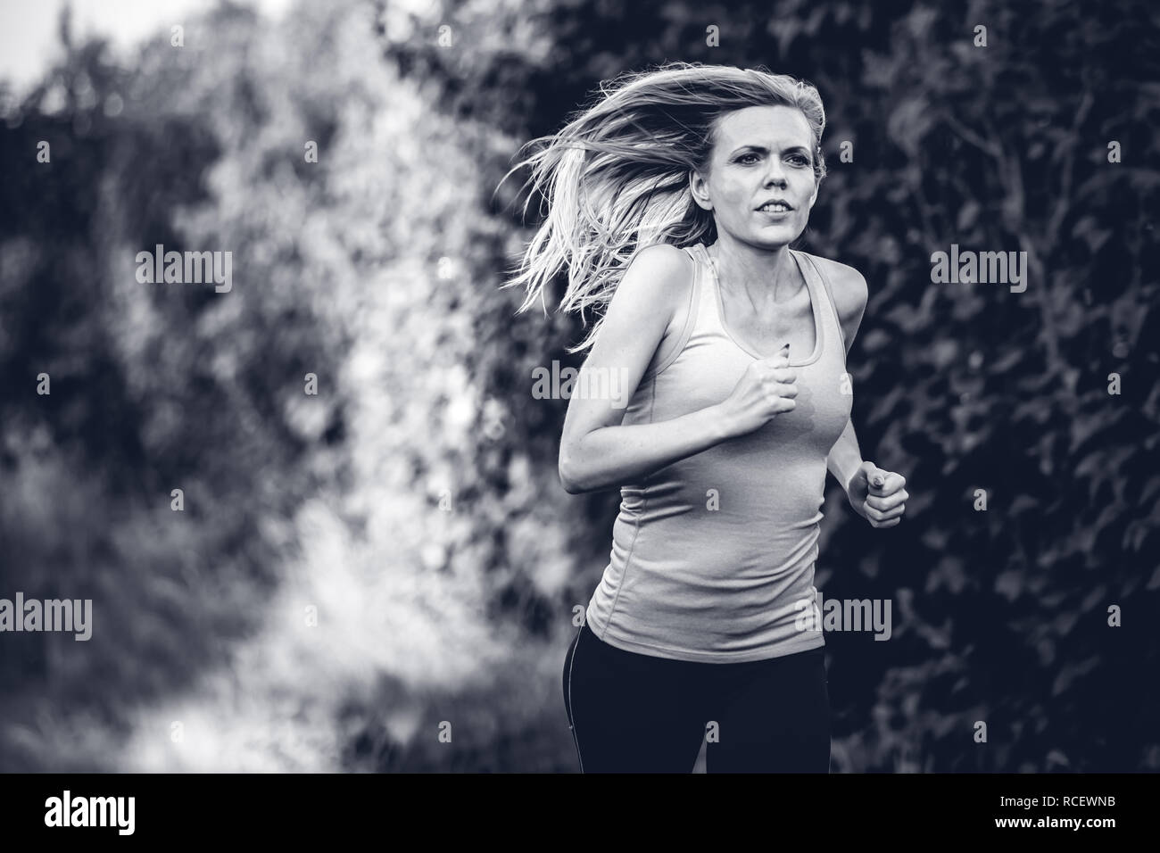Slim fitness woman running outdoors Stock Photo - Alamy