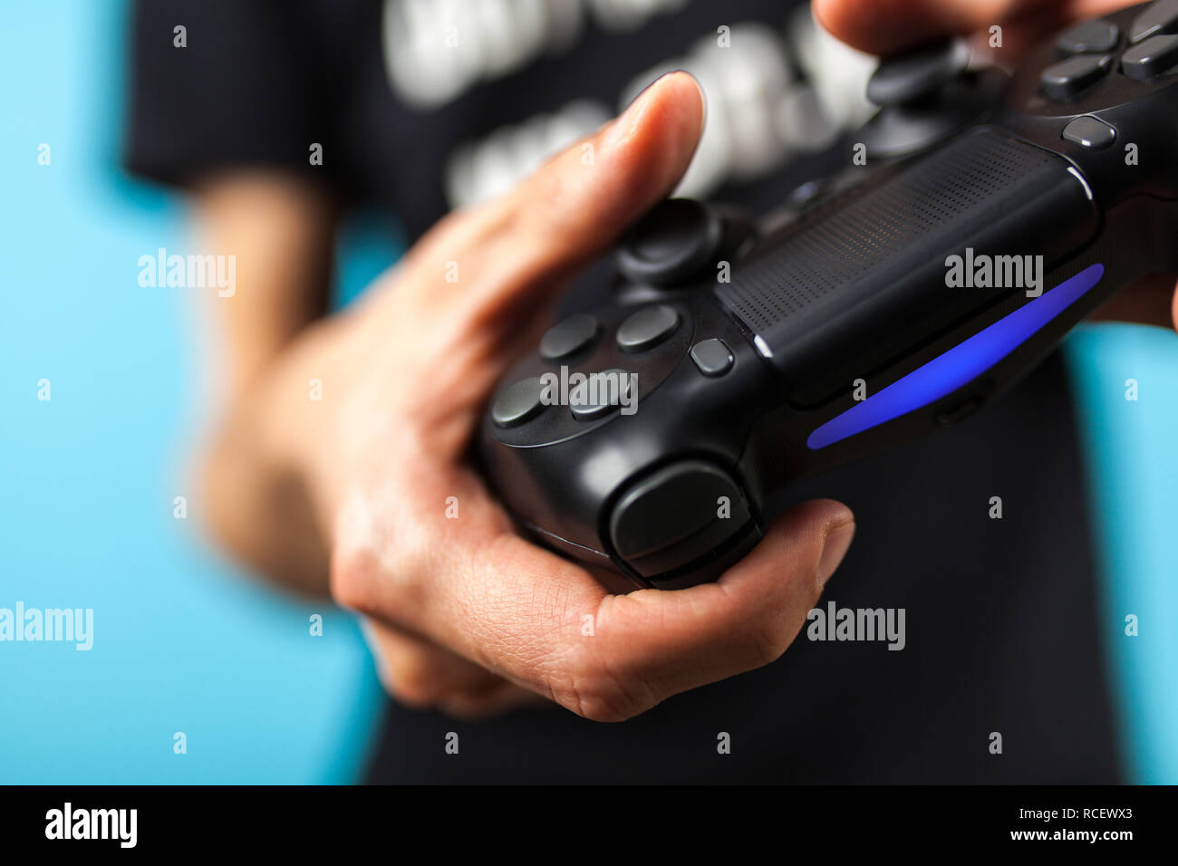 Male hands holding a gaming console controller Stock Photo - Alamy