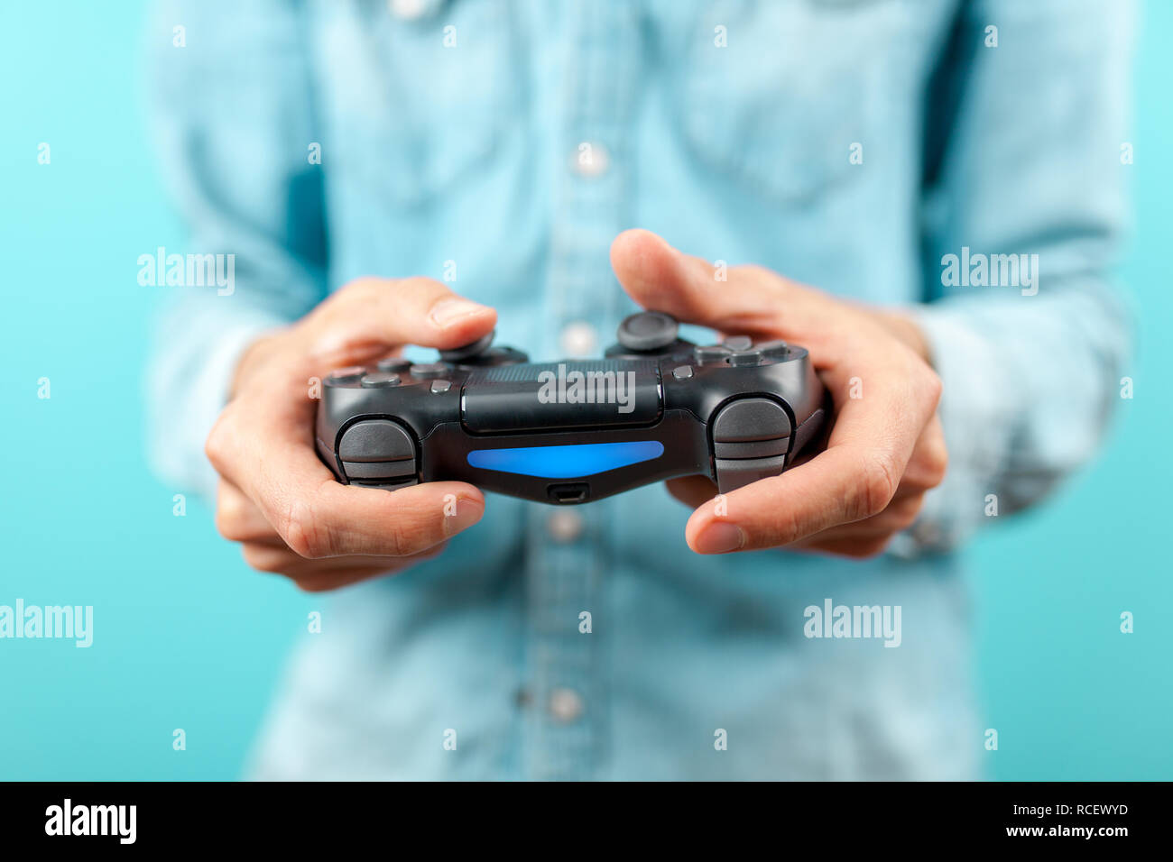 Male hands holding a gaming console controller Stock Photo - Alamy