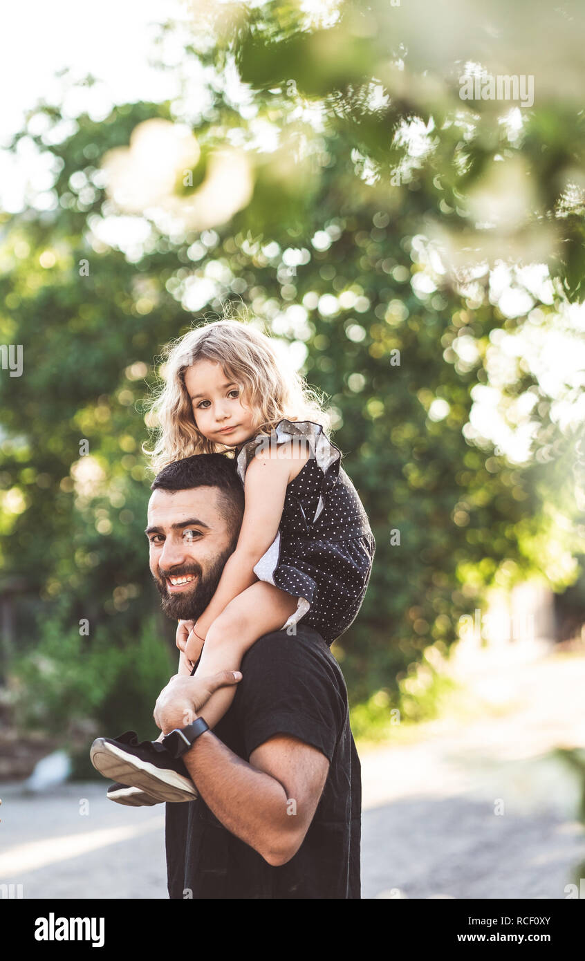 A little daughter sits on the shoulders Stock Photo - Alamy