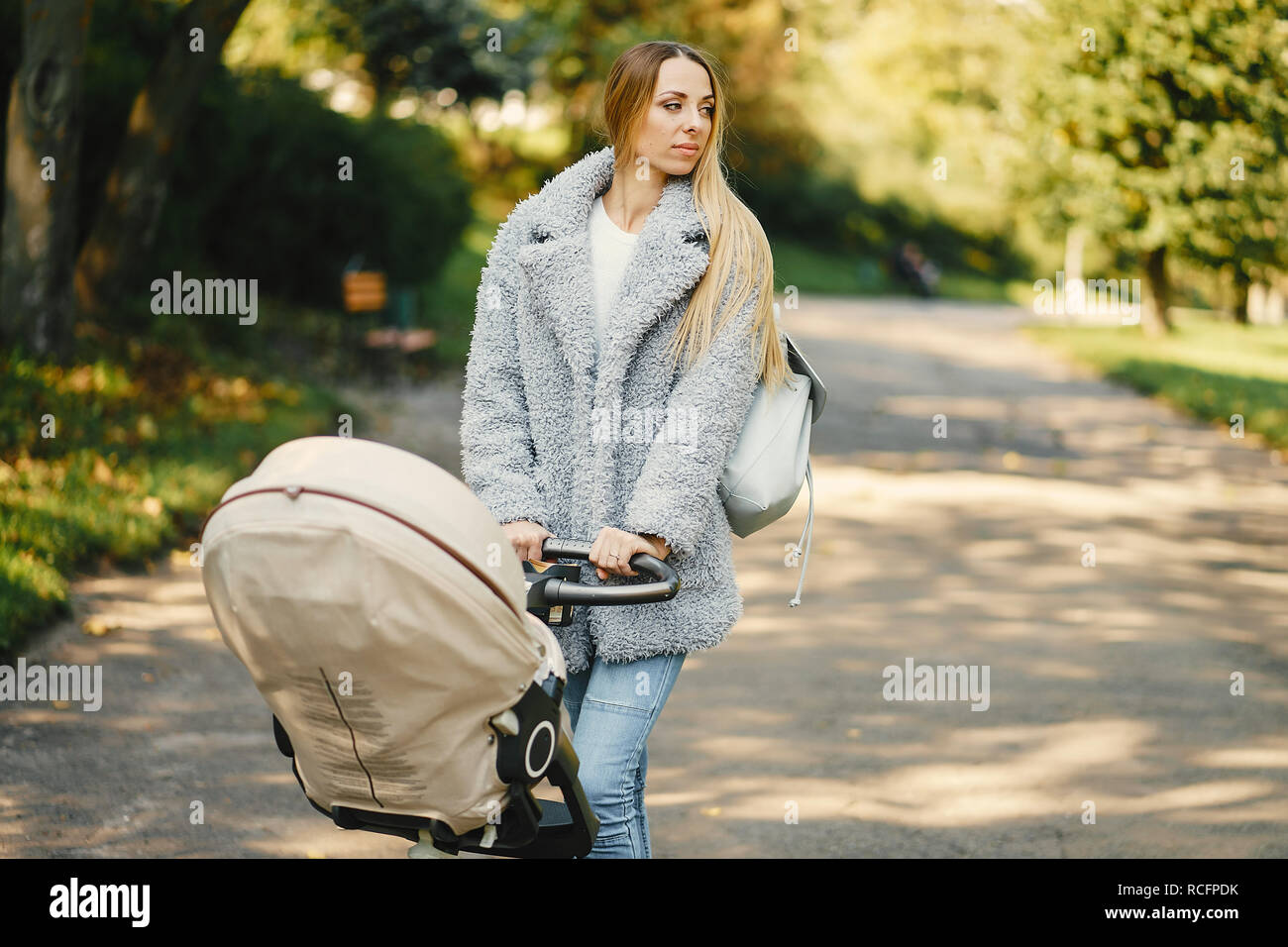 young mother pushing a stroller Stock Photo - Alamy