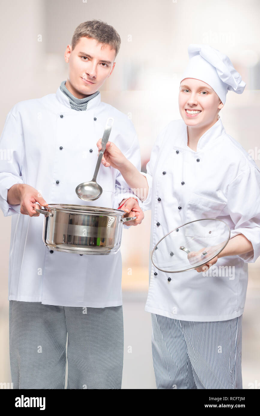 successful professional chefs with a pan and a ladle in a commercial ...