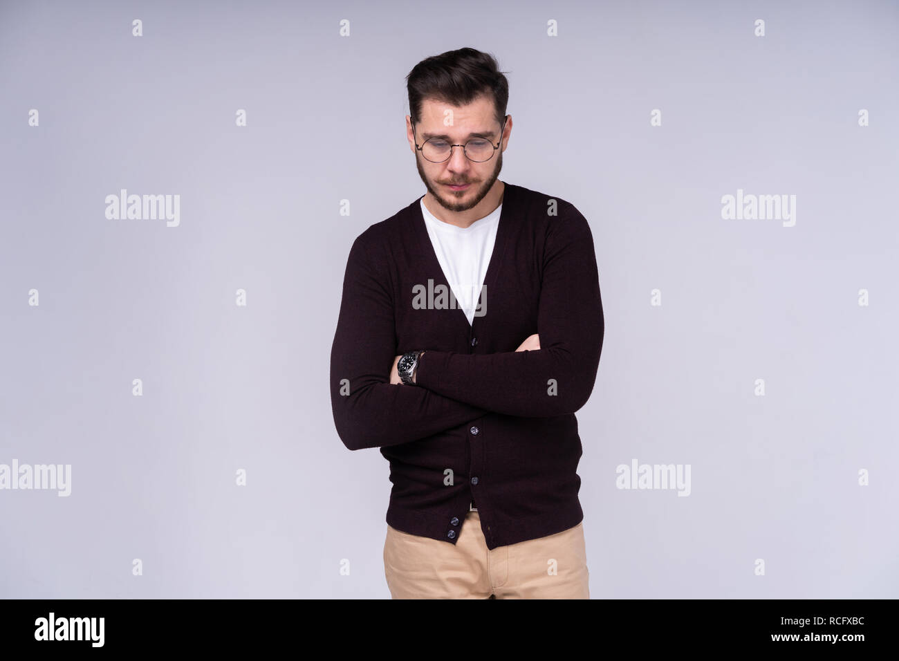 Portrait of sad upset young guy looking at camera over white background ...