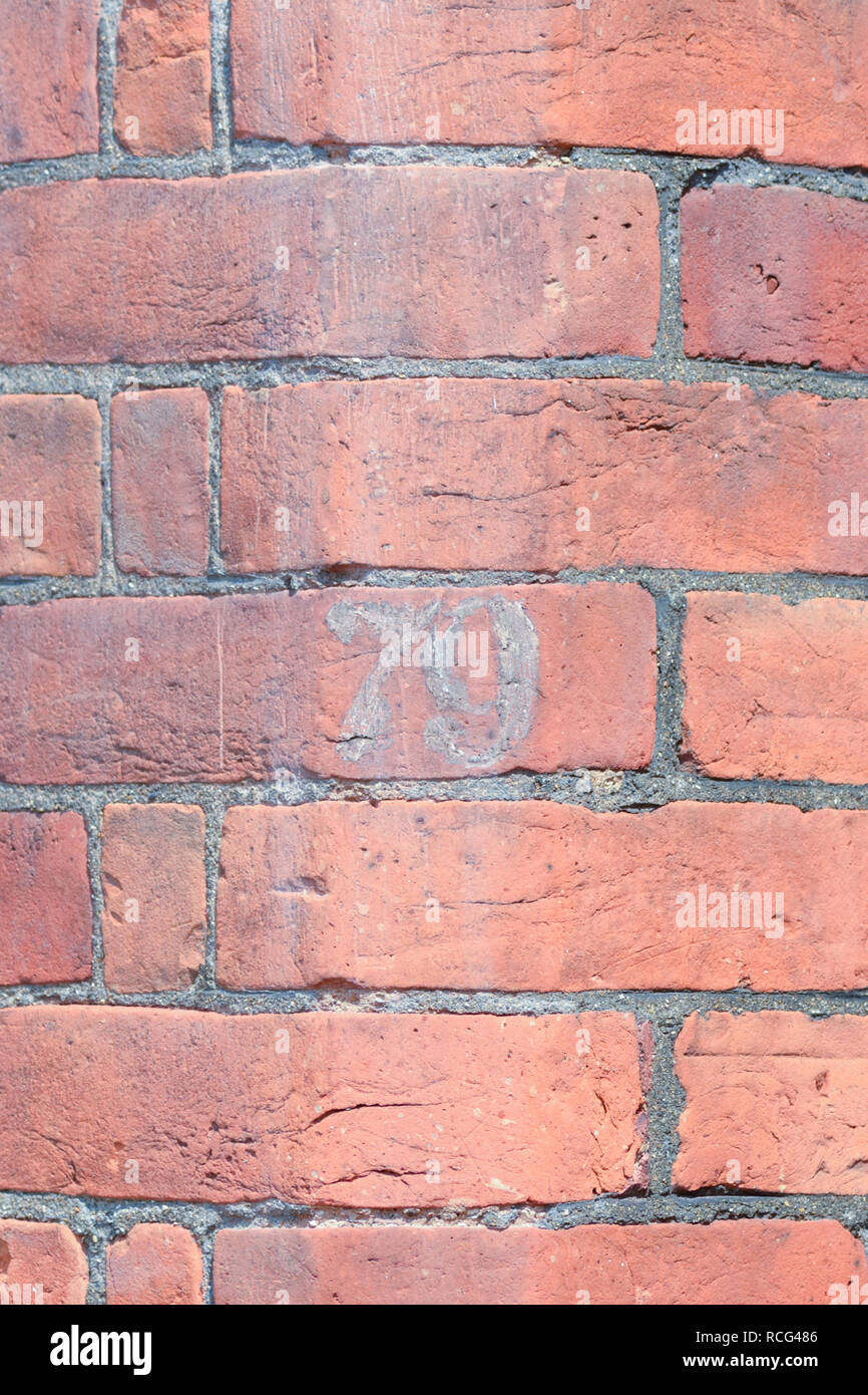 House number 79 sign - painted on red brick wall Stock Photo - Alamy