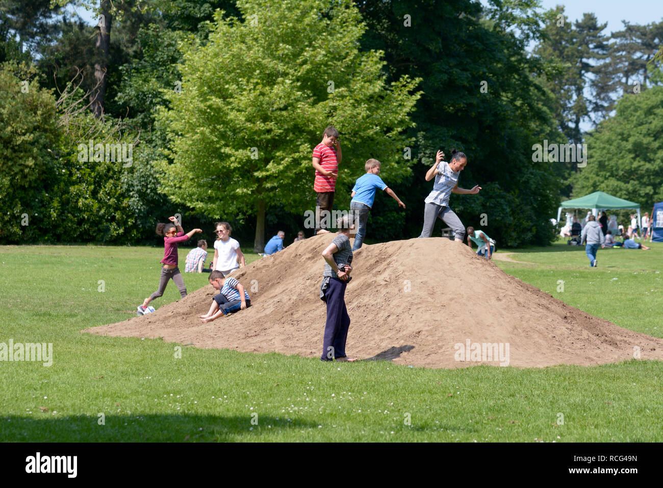 Children using their imaginations to turn a pile of mud in the park ...